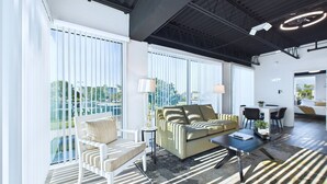 Uma sala de estar moderna com sofá, poltrona, mesa de centro e um espaço de refeições com mesa e cadeiras.