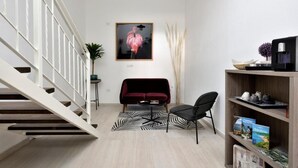 Uma sala de estar moderna com escada, um sofá vermelho, uma cadeira preta, um tapete com padrão de zebra, uma estante de madeira e um quadro na parede.