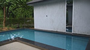 Piscina ao lado de um edifício com telhado em azulejo.