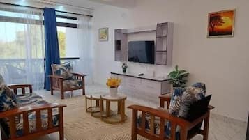 Apartamento Deluxe, varanda | Sala de estar | Televisor