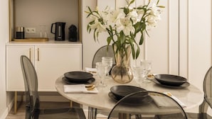 Uma mesa de jantar posta com pratos, copos e um vaso de flores brancas.