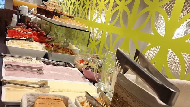 Um buffet com diversos alimentos e utensílios.