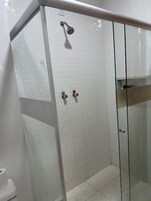 Chuveiro, toalhas de banho, sabonete, shampoo