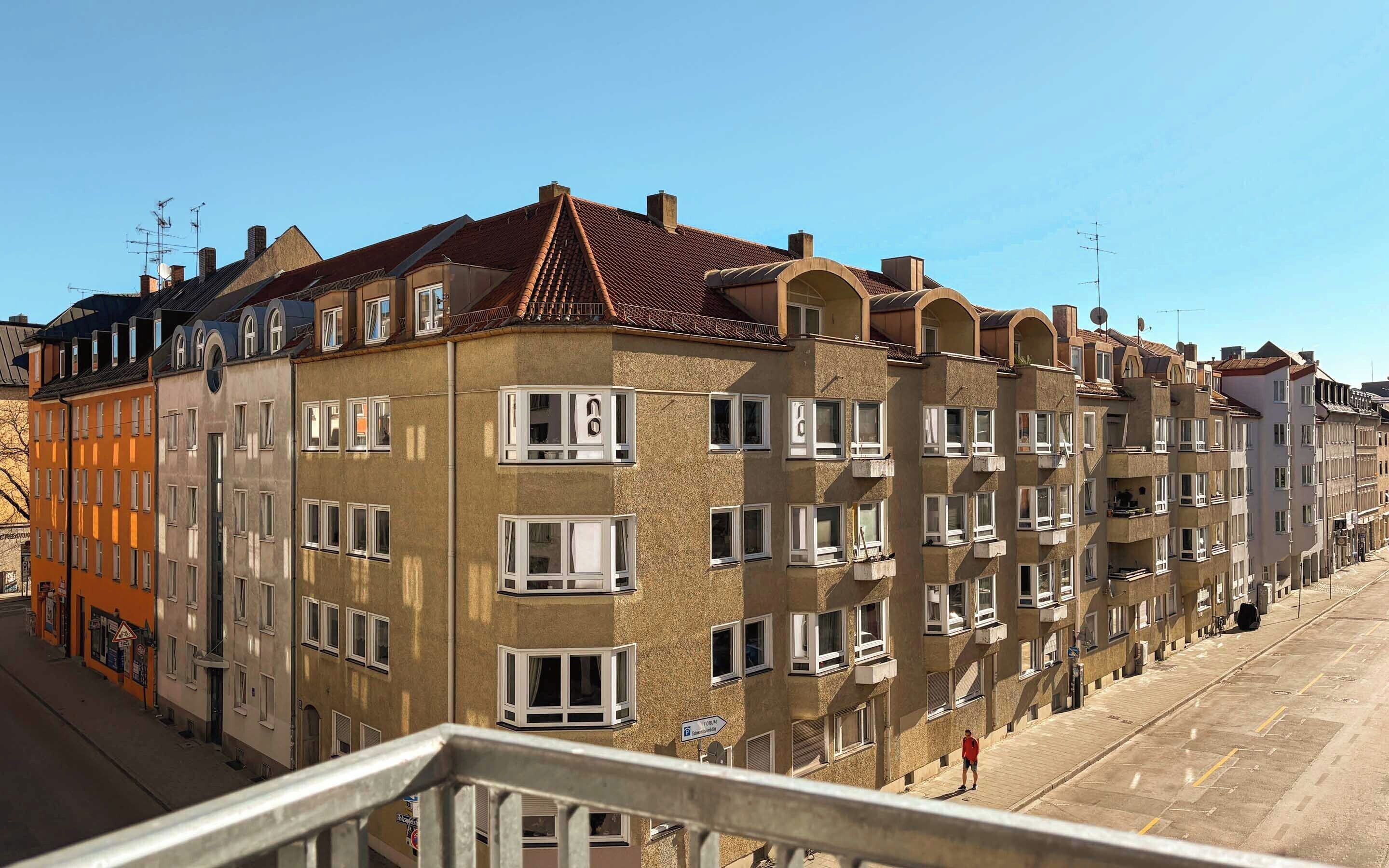 Um edifício residencial com vários andares, telhado plano, várias janelas e varandas.