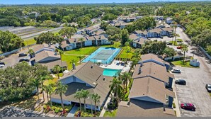 Vista aérea de um bairro residencial com casas, piscina e estacionamento.