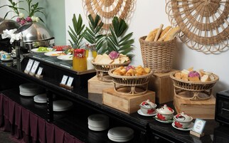 Disposição de buffet com diversos alimentos, cestas e recipientes de servir.