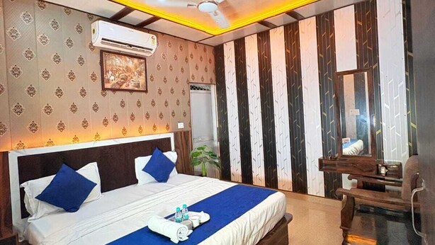 Quarto de hotel com uma cama grande, uma escrivaninha e um ventilador de teto.