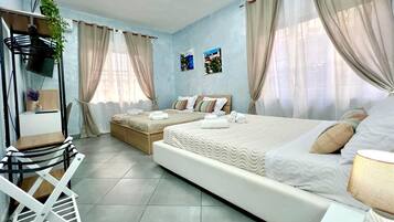 Quarto com cama, escrivaninha, cadeira e televisão.