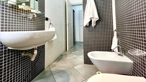 Uma casa de banho moderna com uma grande pia, uma banheira e zona de duche.
