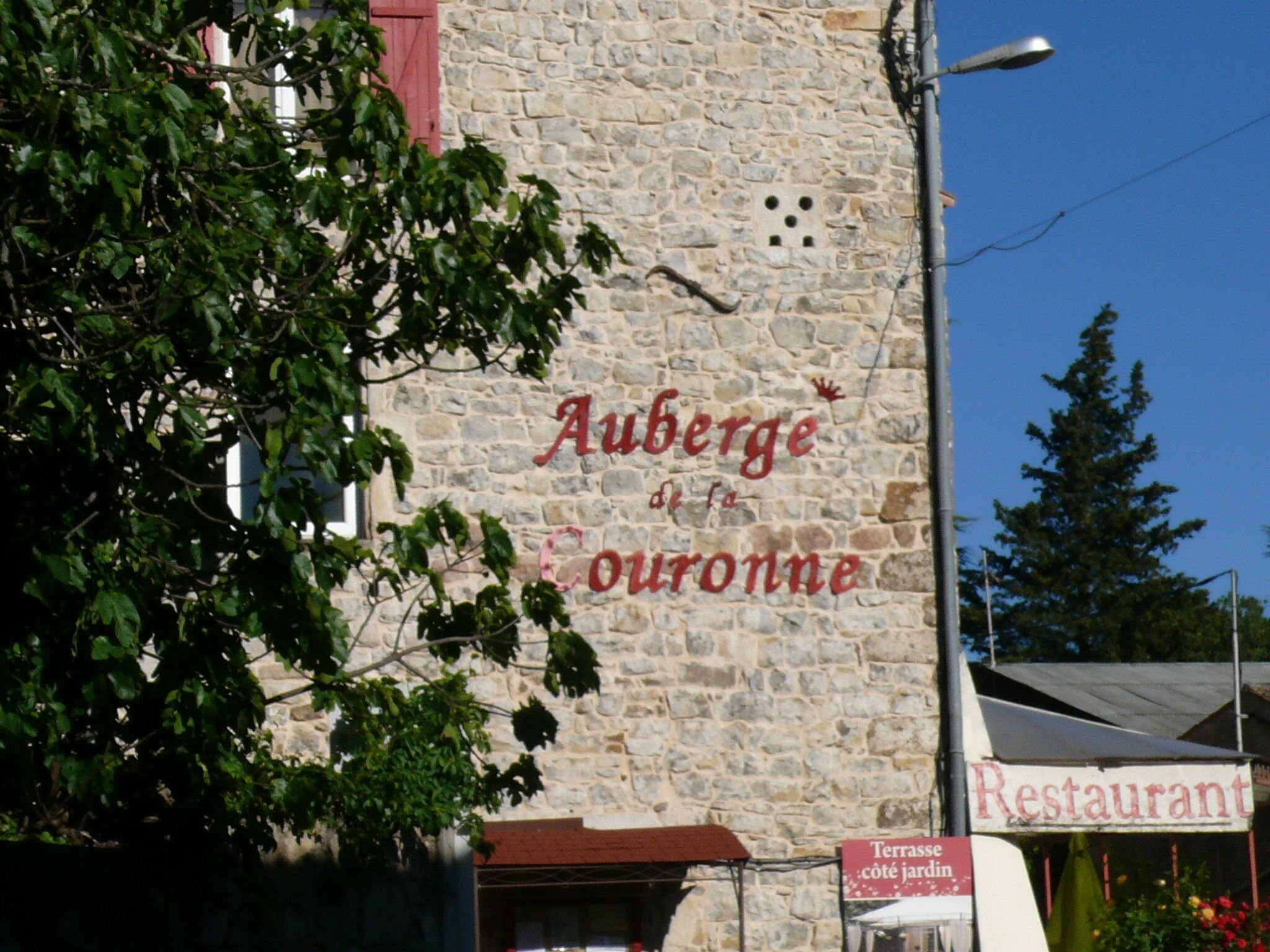 Um edifício de pedra com uma placa que diz 'Auberge de la Couronne'.