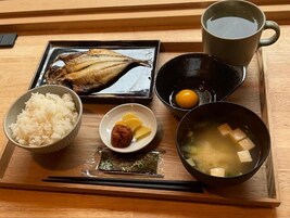 Uma bandeja com peixe, arroz, um pires de picles, uma tigela de sopa, uma xícara de chá e um pacote de alga marinha.