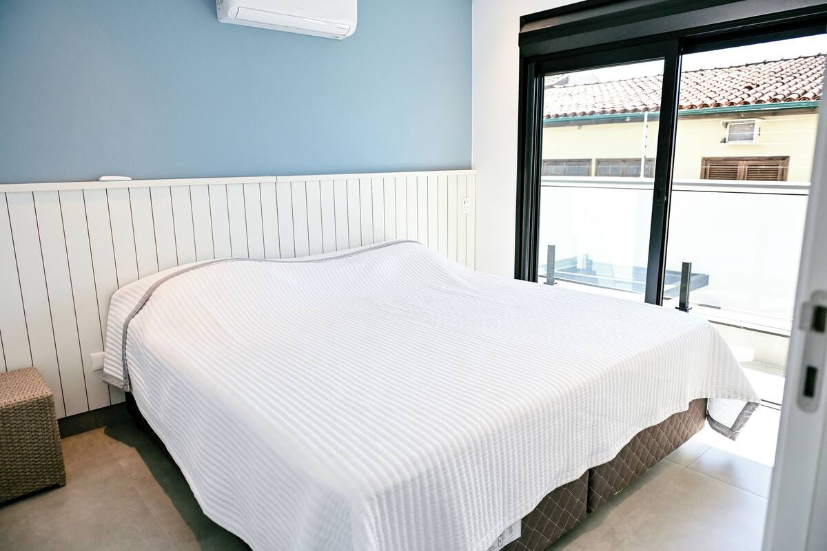 Quarto com cama, janela e vista para o exterior.