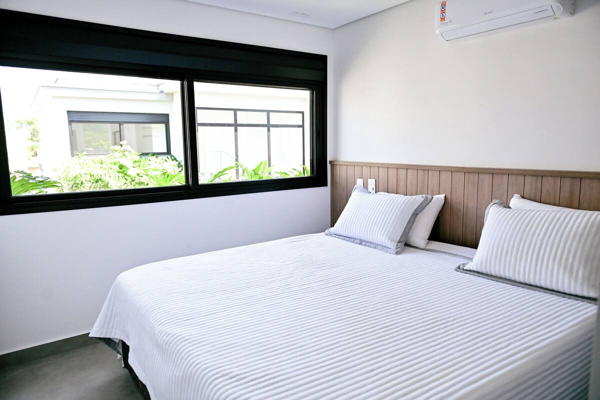 Quarto com uma cama, janela e ar condicionado.