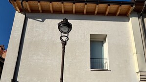 Um poste de luz em frente a um edifício com fachada de pedra e duas janelas.