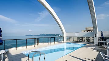 Piscina no terraço com vista ampla para o mar e ilhas ao longe.