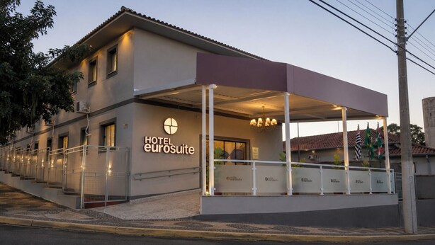 Um hotel com fachada moderna, entrada coberta e placa indicando ser um Eurosuite.