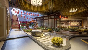 Interior em estilo tradicional com um caminho curvo, uma peça central de pedra e vista para um edifício com sinalização.