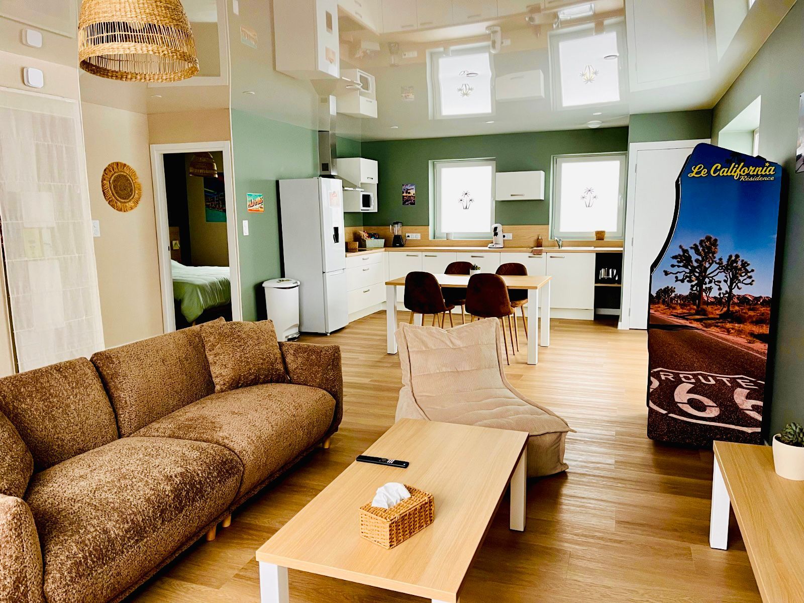 Uma sala de estar moderna com sofá, mesa de centro e área de cozinha ao fundo.