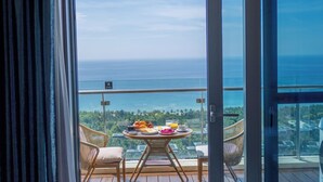 Varanda com mesa posta para café da manhã, com vista para a costa.