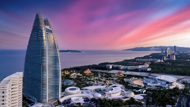 Um hotel moderno com design curvo único, área de piscina e vista para o mar.