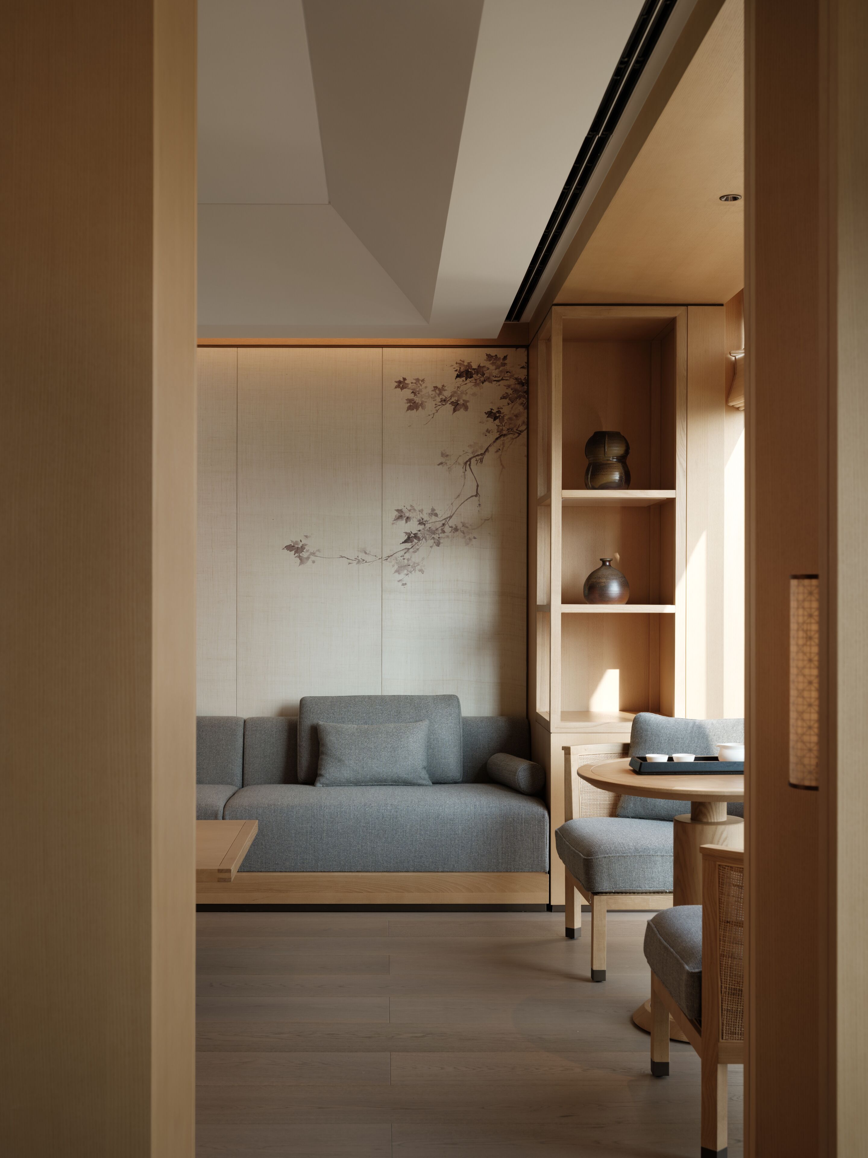 Um interior moderno com um sofá, uma mesa pequena e um painel decorativo.