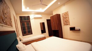 Quarto com cama, ventoinha no teto, ar condicionado, janela com grades e prateleira fixada na parede.