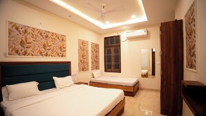 Quarto com duas camas, ventilador de teto, ar condicionado e guarda-roupa de madeira.