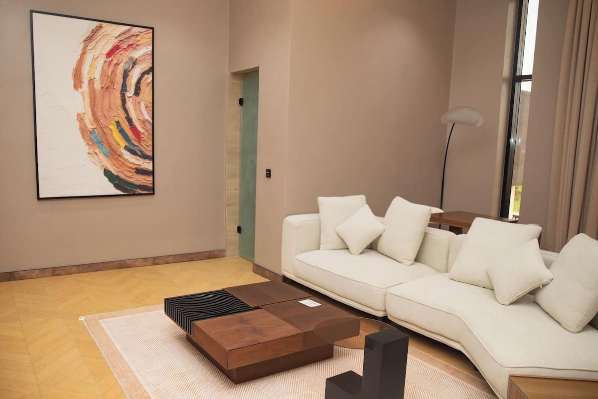 Uma sala de estar moderna com um sofá branco, uma mesa de centro e um abajur.
