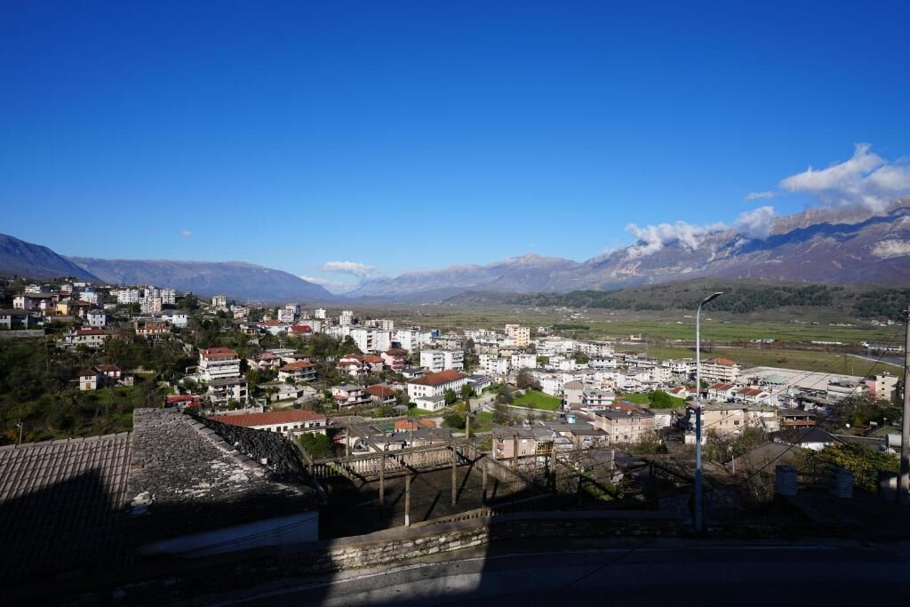 Uma cidade com edifícios e montanhas ao fundo.