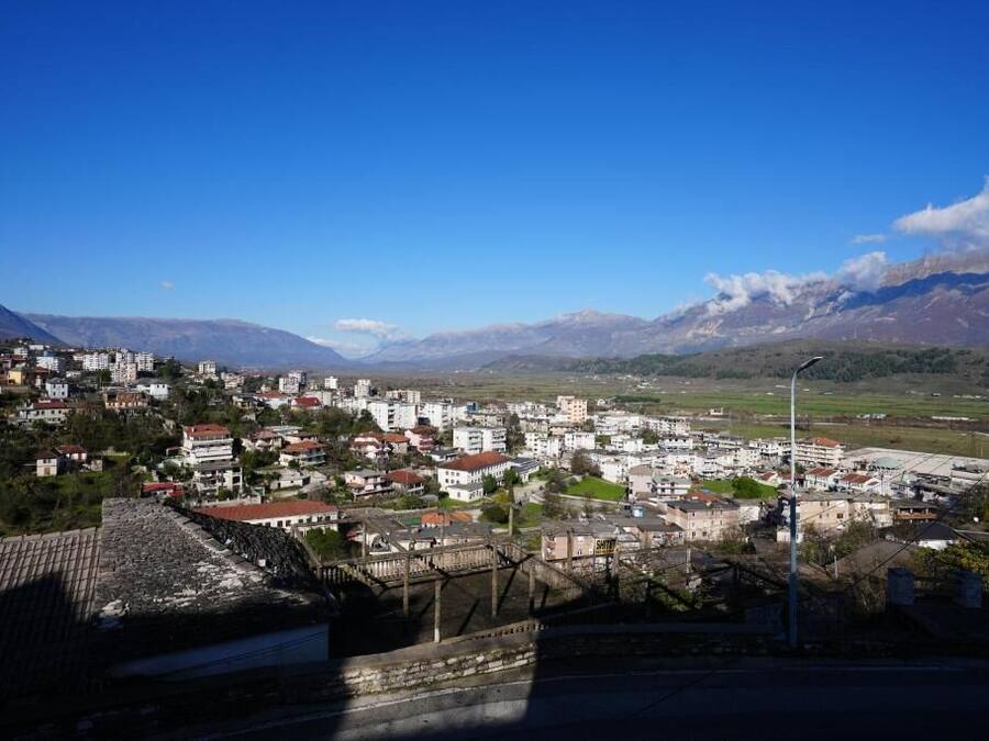 Uma cidade com edifícios e montanhas ao fundo.