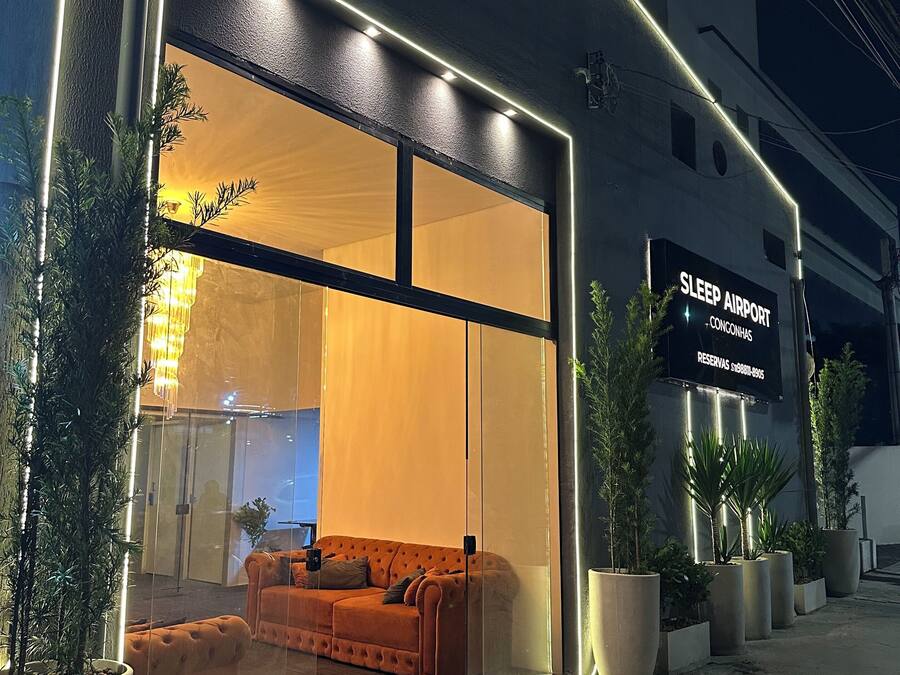 Um edifício moderno com uma placa que diz 'SLEEP AIRCON - CONCONHAS RESERVAS 8880-8885'.
