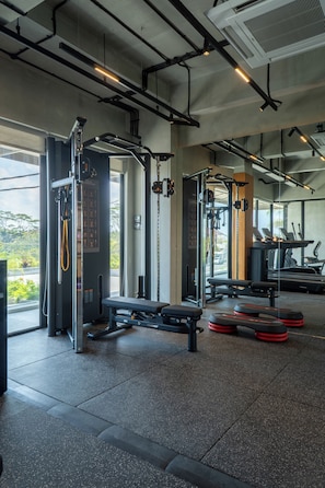 Uma academia com diversos equipamentos de exercício, incluindo máquinas de peso e esteiras.