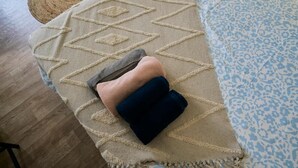 Um sofá com um cobertor estampado e duas almofadas.