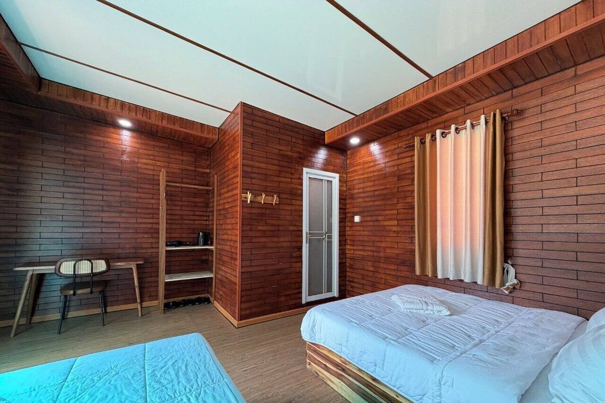 Um quarto com uma cama, uma escrivaninha e um guarda-roupa.