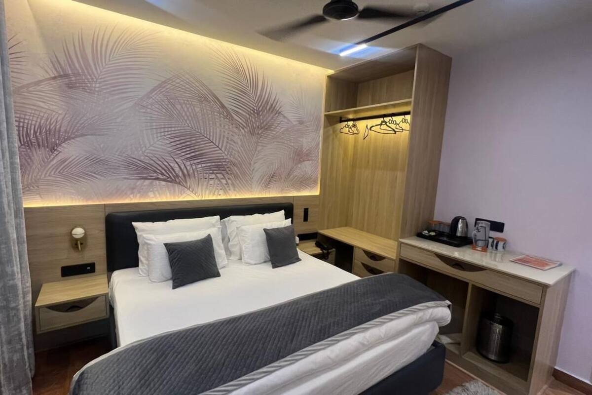 Quarto de hotel moderno com uma cama grande, uma escrivaninha e um guarda-roupa.