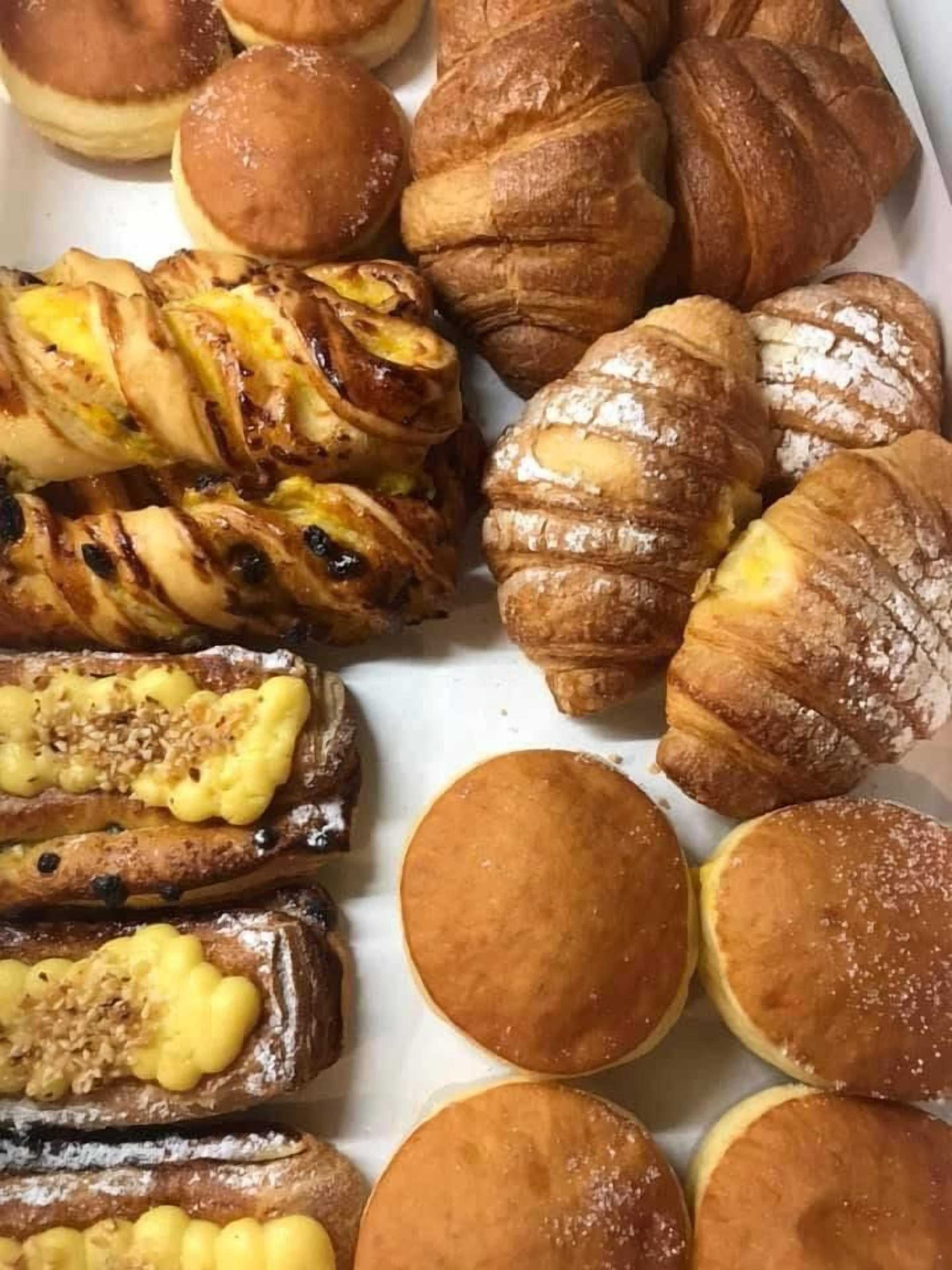 Diversos produtos de panificação, incluindo croissants, pães e doces.