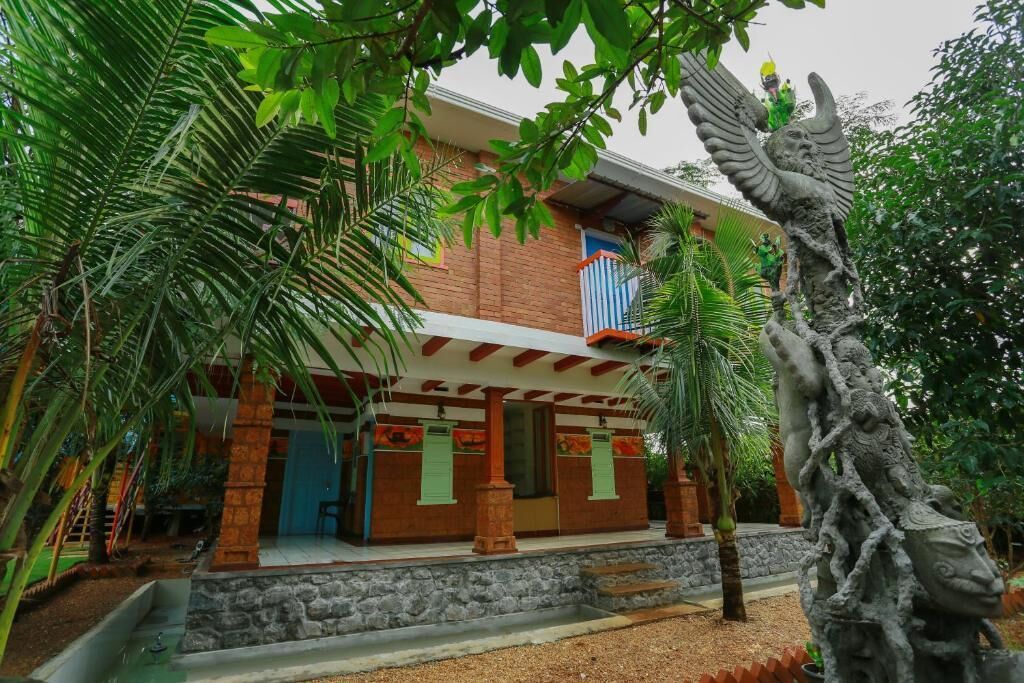 Um edifício com fachada de tijolos, varanda e um caminho de pedra que leva à entrada.