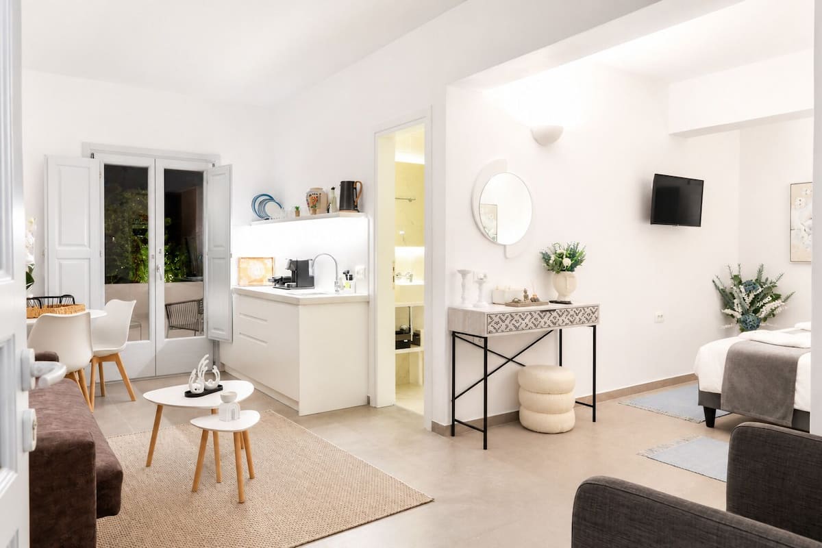 Uma sala de estar moderna com sofá, mesa de centro e área de jantar com cadeiras.