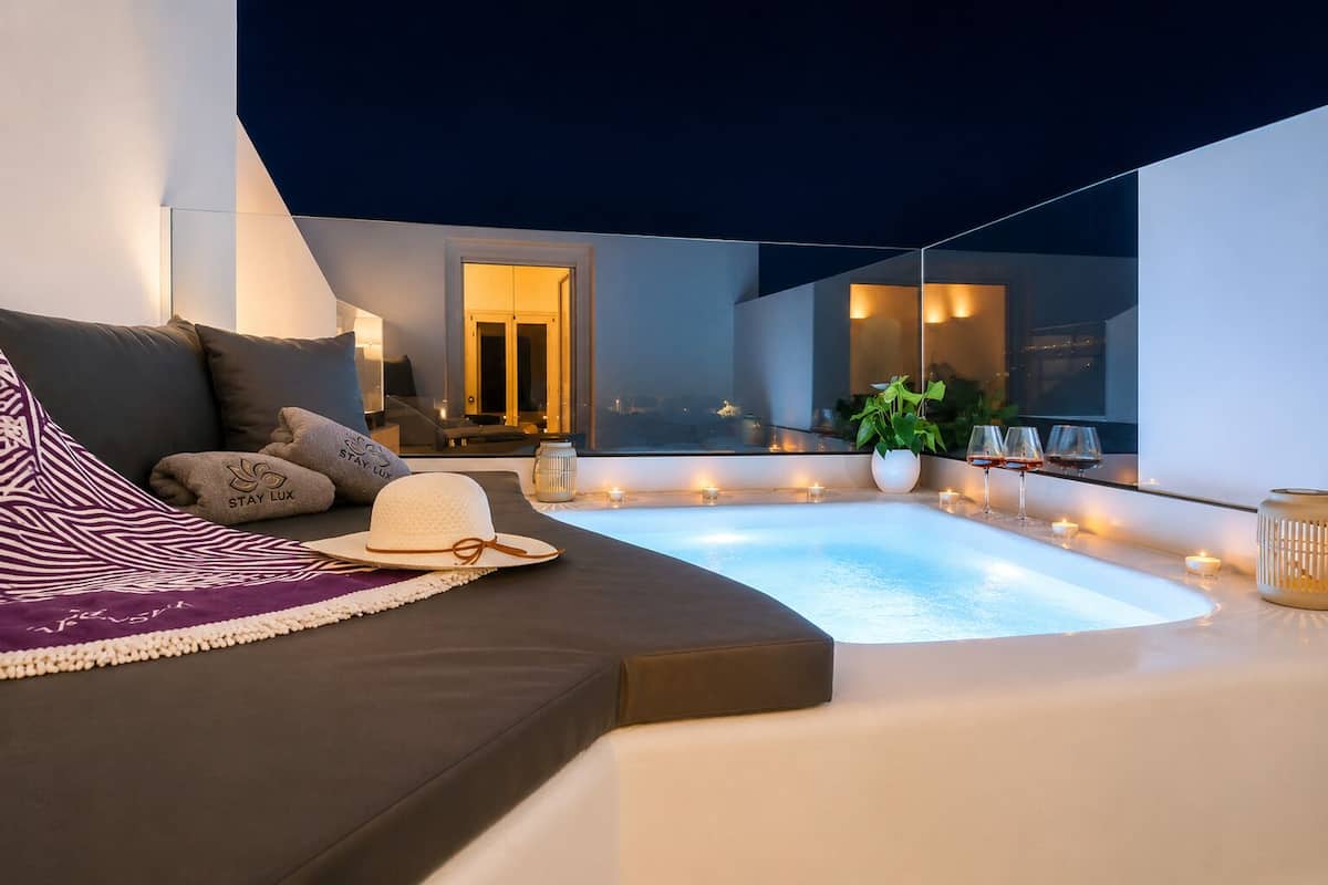 Um lounge moderno no terraço com área de estar externa aquecida, guarda-corpo de vidro e vista para a cidade.