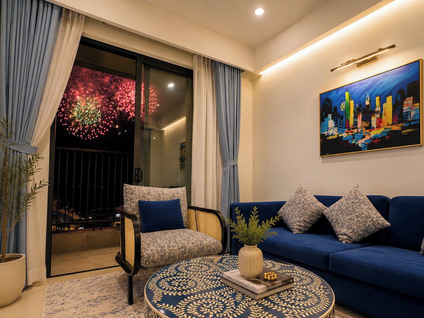Uma sala de estar moderna com sofá, poltrona, mesa de centro redonda e um quadro na parede.