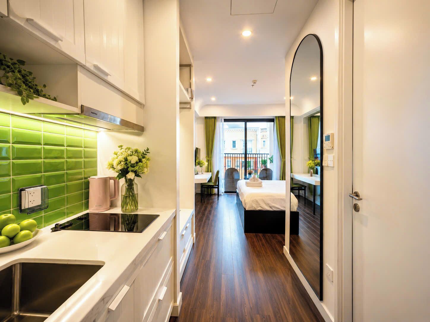 Quarto de hotel moderno com cozinha, área de refeições e varanda com vista.