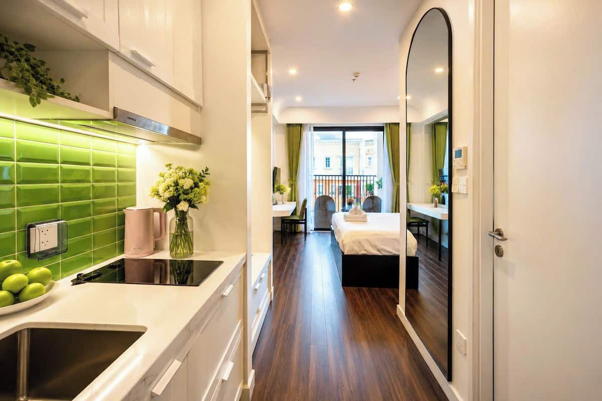 Quarto de hotel moderno com cozinha, área de refeições e varanda com vista.