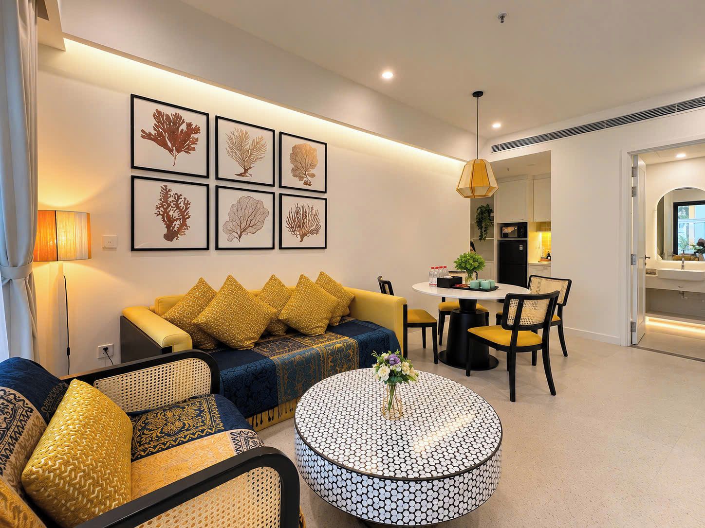 Uma sala de estar moderna com um sofá, mesa de centro redonda e uma obra de arte na parede.
