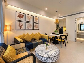 Uma sala de estar moderna com um sofá, mesa de centro redonda e uma obra de arte na parede.