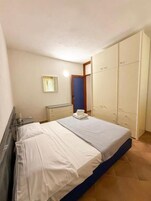 Quarto com cama, penteadeira, guarda-roupa e espelho.