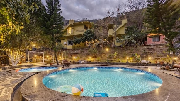 Uma piscina circular com um centro azul cristalino, rodeada por um deck de pedra.