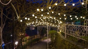 Um caminho com iluminação decorativa e grades de metal.