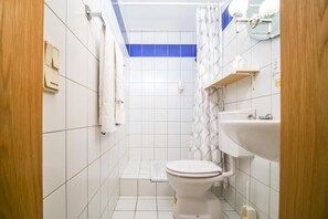 Quarto duplo básico | Banheiro | Chuveiro, toalhas de banho, sabonete, shampoo