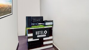 Uma mesa de recepção com uma placa indicando 'HOTELO Company-Serviced'.