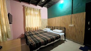 Quarto com cama, parede de madeira, televisão e cortinas.